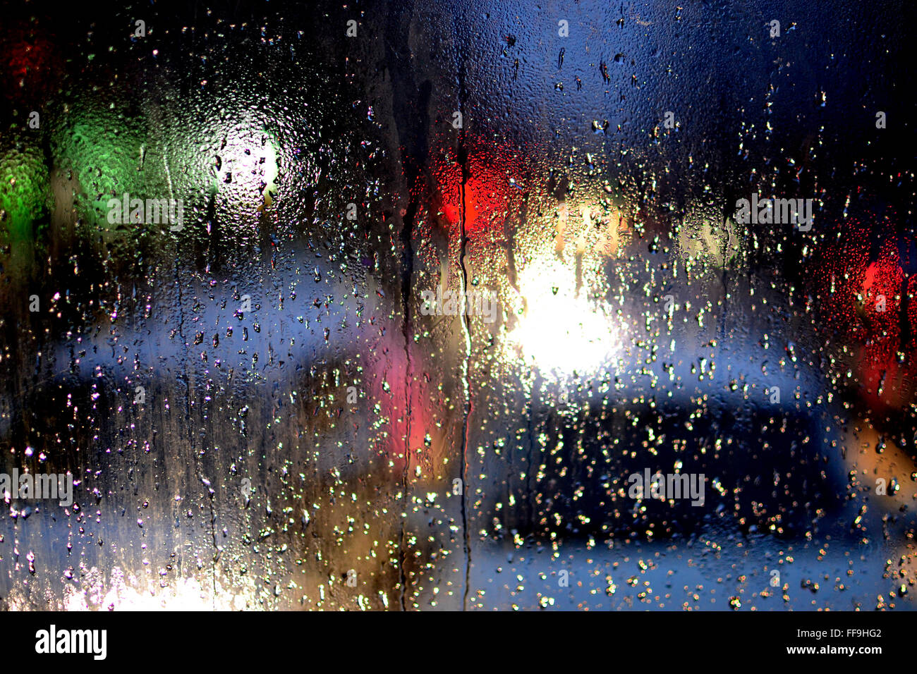 Rain drops on window and bokeh traffic lights background Stock Photo ...
