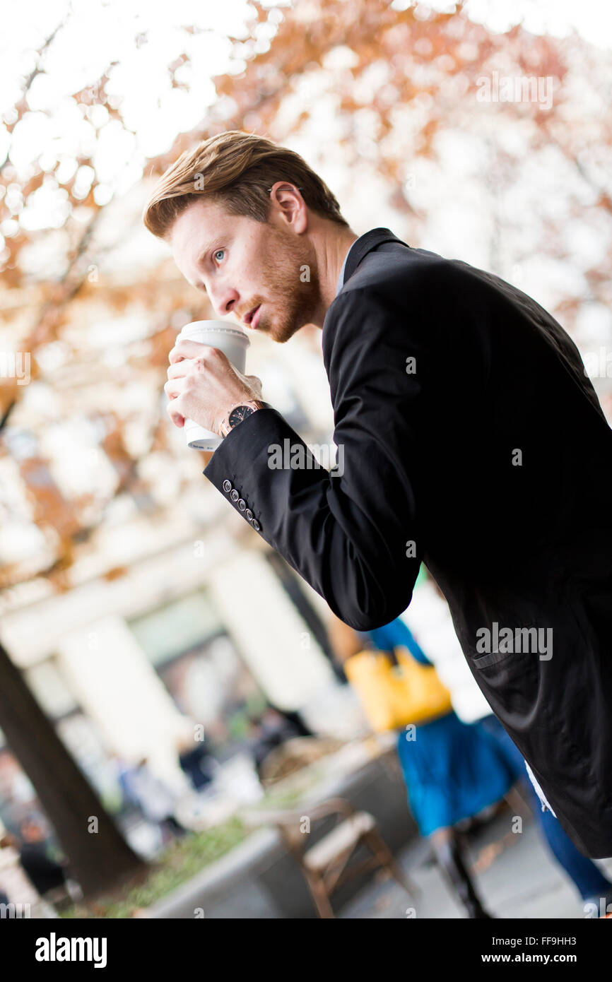 Young man drinking coffee to go on street Stock Photo - Alamy