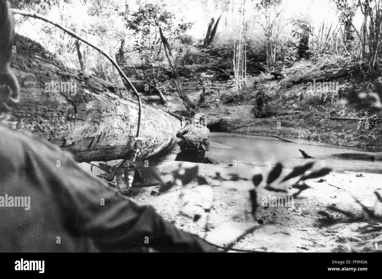 VIETNAM WAR: U.S. SOLDIER. /nAn American soldier ducks behind a fallen ...