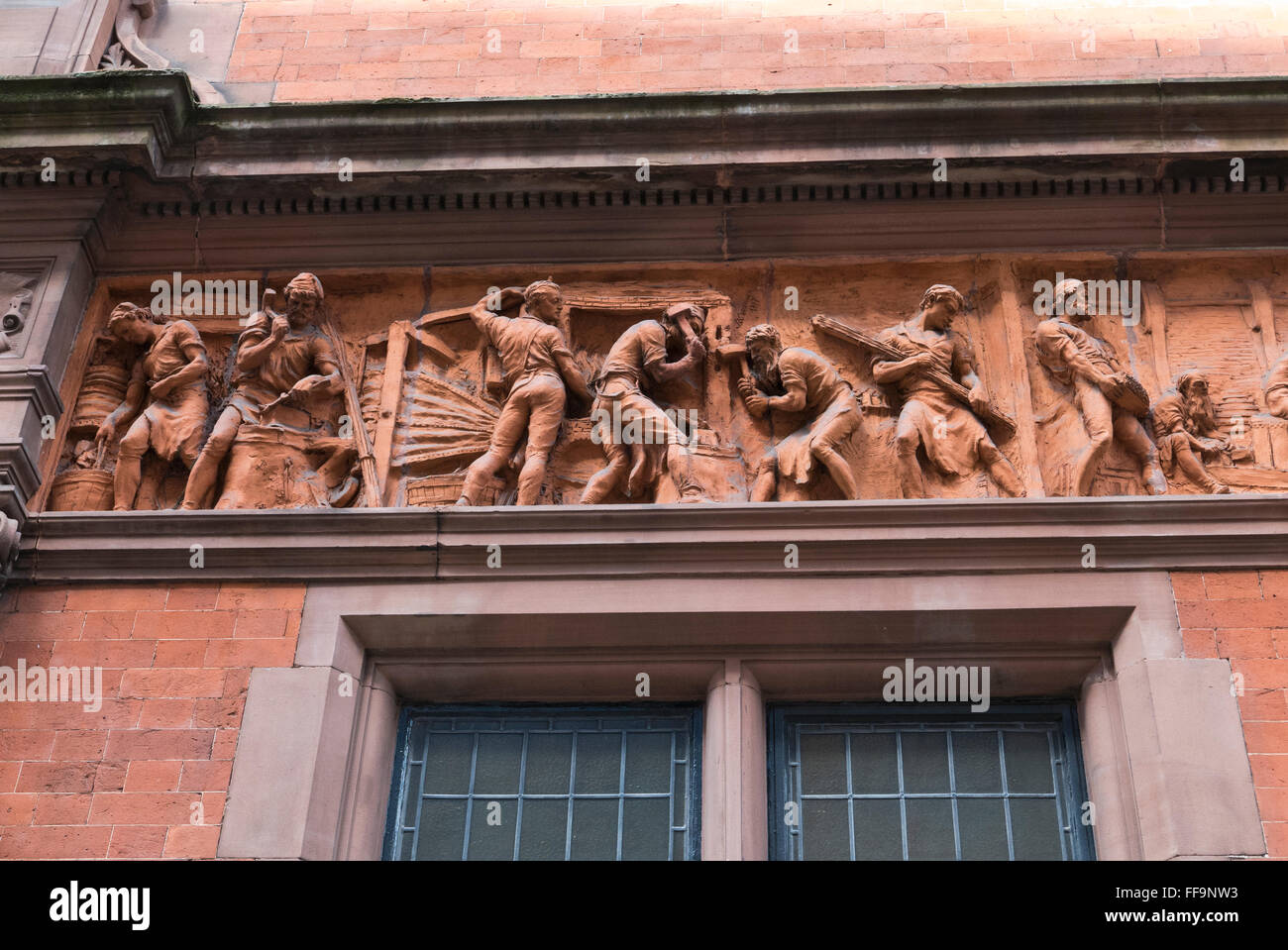 Stone carvings of men at work on the exterior wall of the Worshipful ...