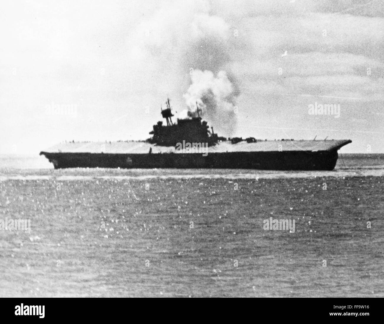 WORLD WAR II: MIDWAY, 1942. /nThe U.S.S. Yorktown listing to one side ...