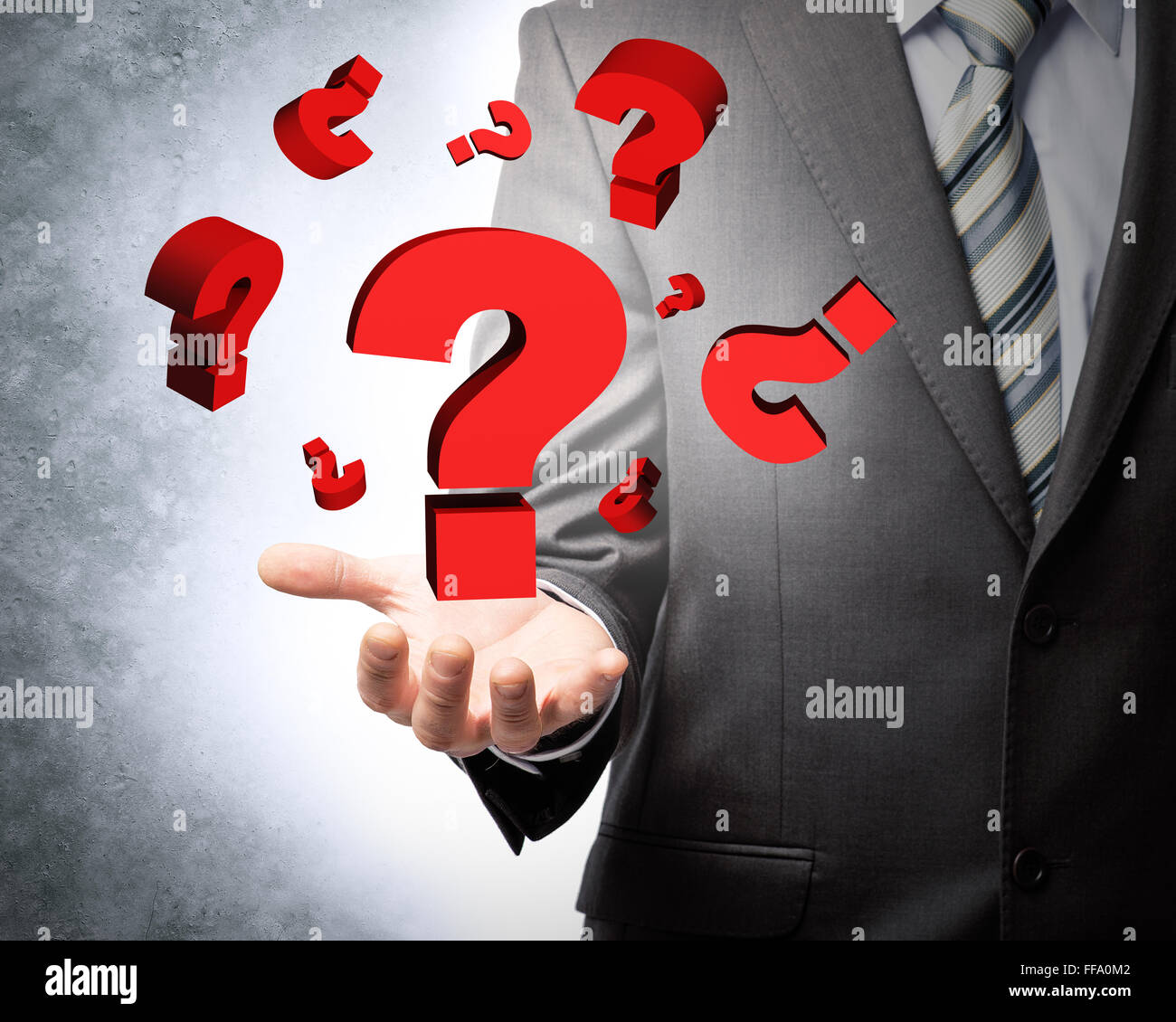 Businessman holding question marks Stock Photo - Alamy