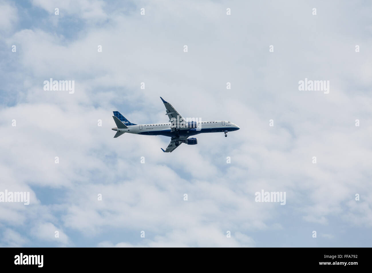A commercial JetBlue airplane flying across the sky Stock Photo - Alamy