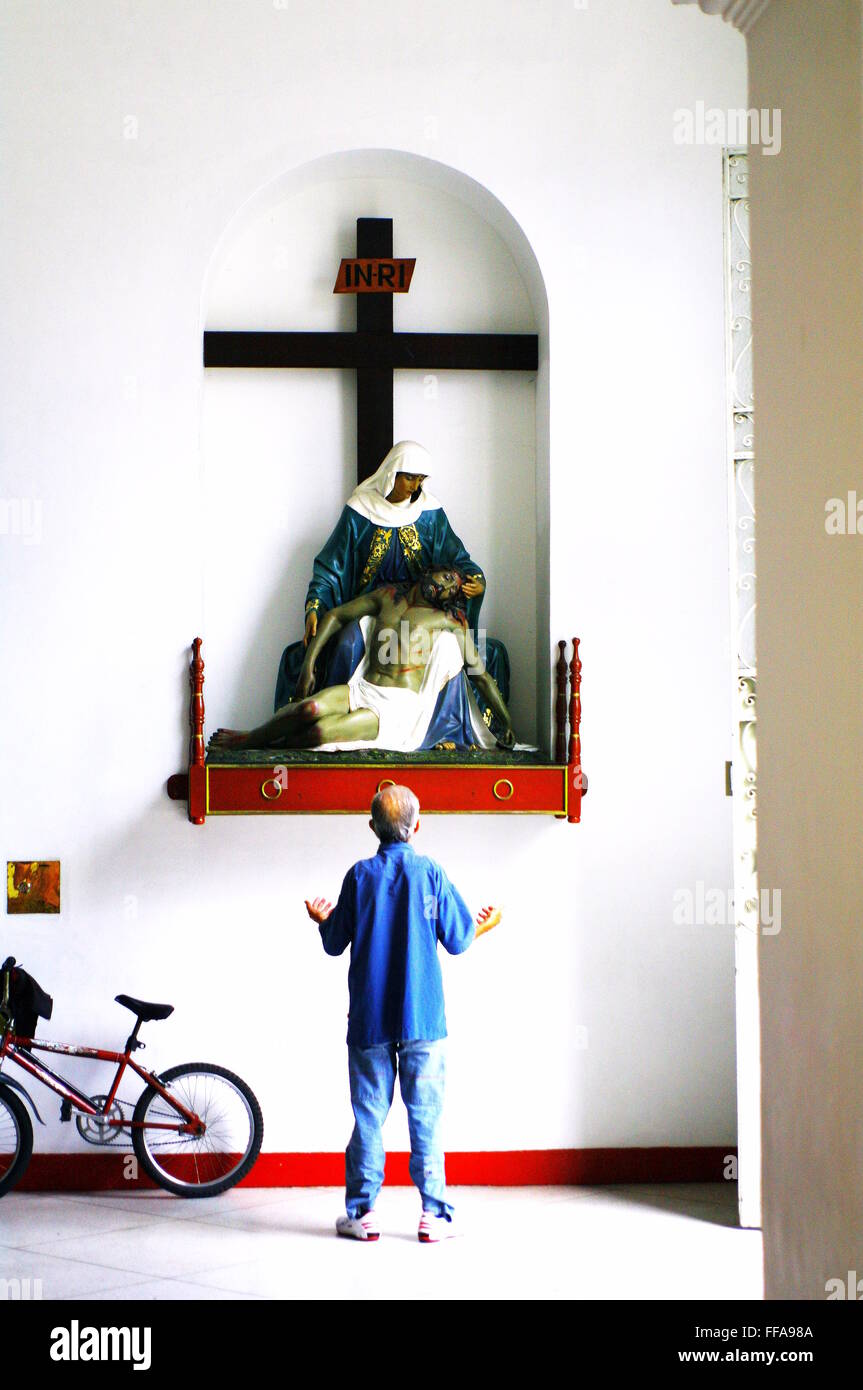 Man venerating image in catholic church Stock Photo - Alamy