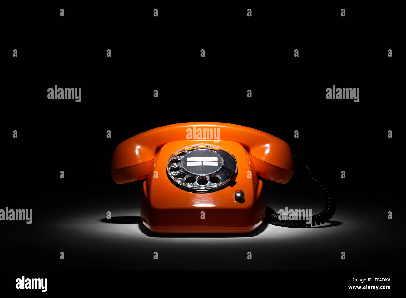 old orange retro phone on black background Stock Photo - Alamy