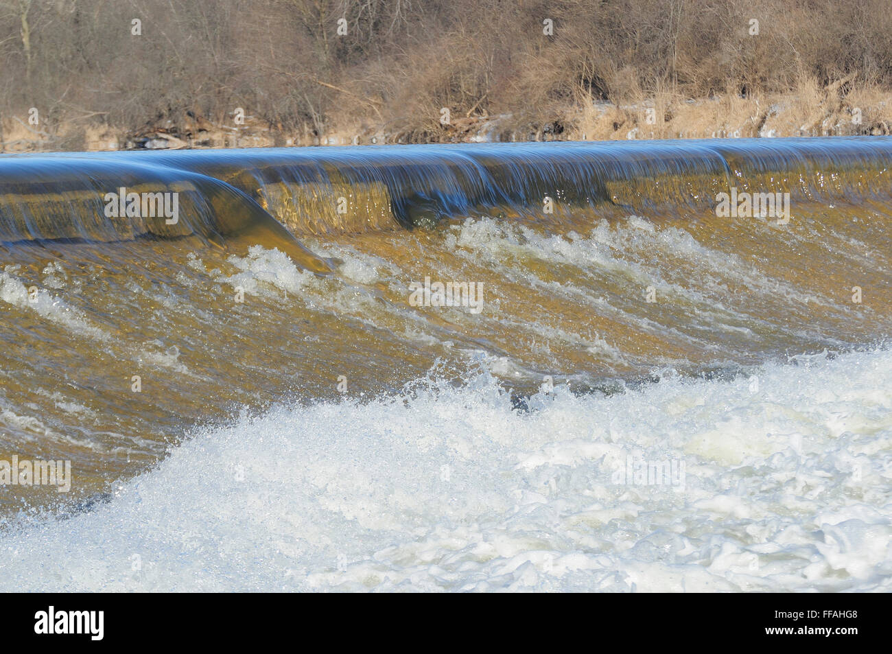 Water flowing over dam on river Stock Photo - Alamy