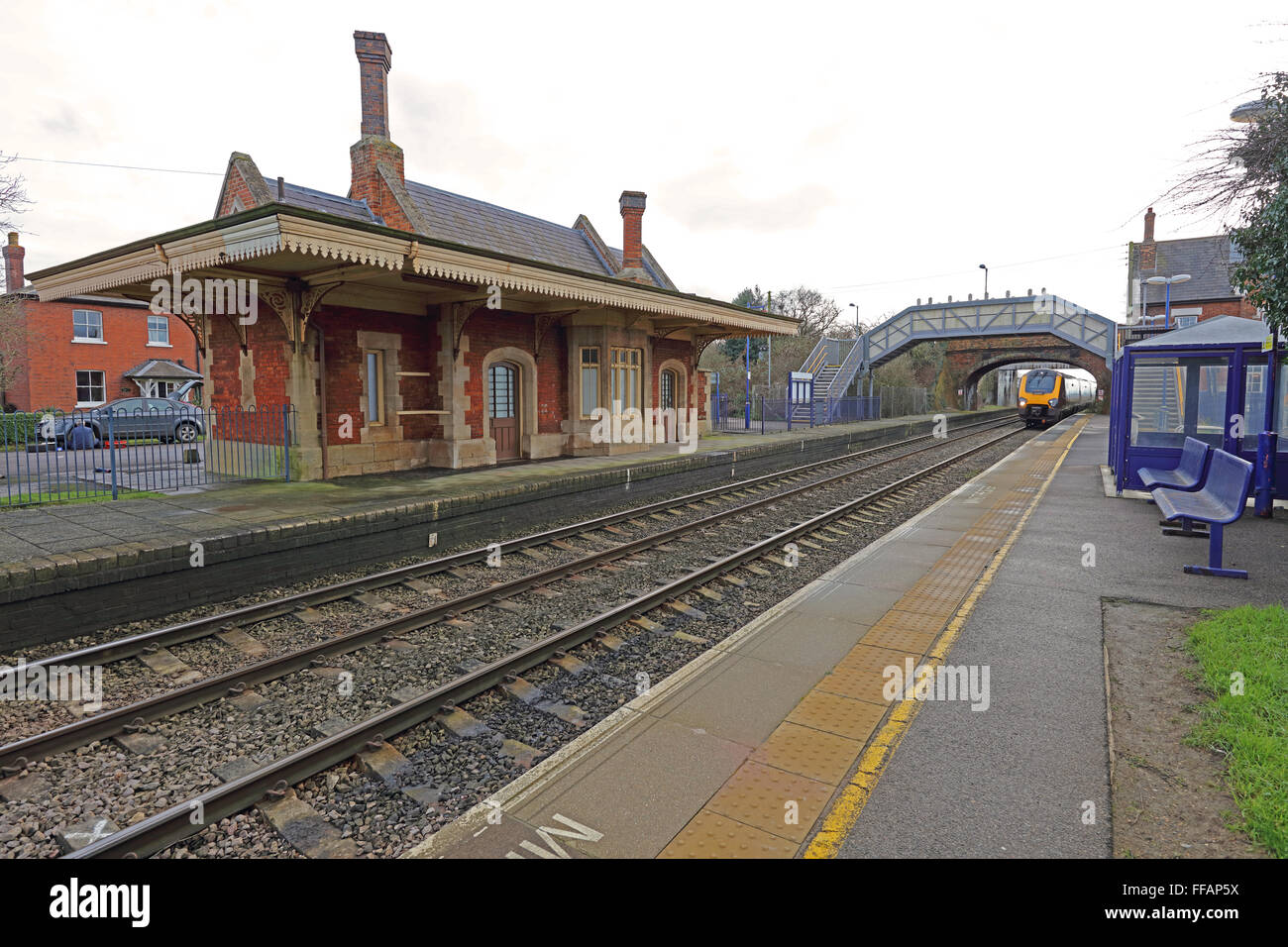 Looking across the tracks at an old station building with a wooden ...