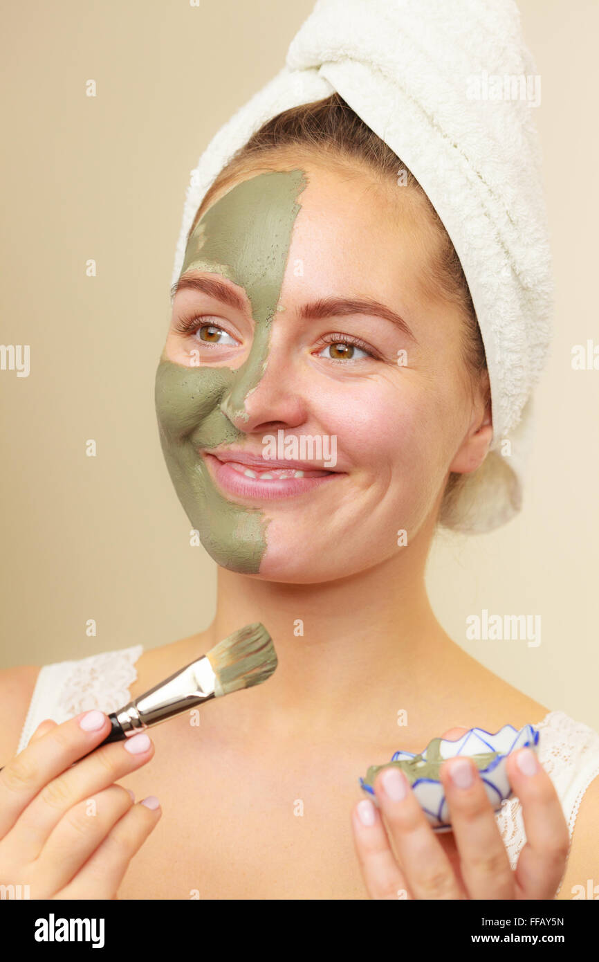 Skin care. Woman applying with brush clay mud mask to her face. Girl ...