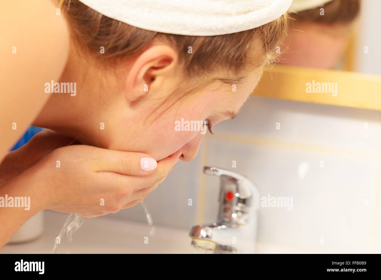 Woman cleaning washing her face with clean water in bathroom. Girl ...