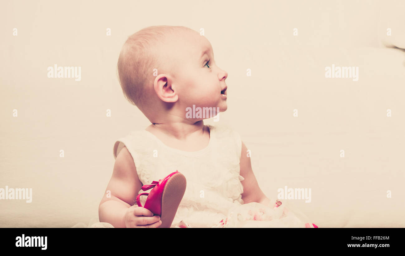 Lesson of walking. Sweet adorable baby girl thinking about make step ...