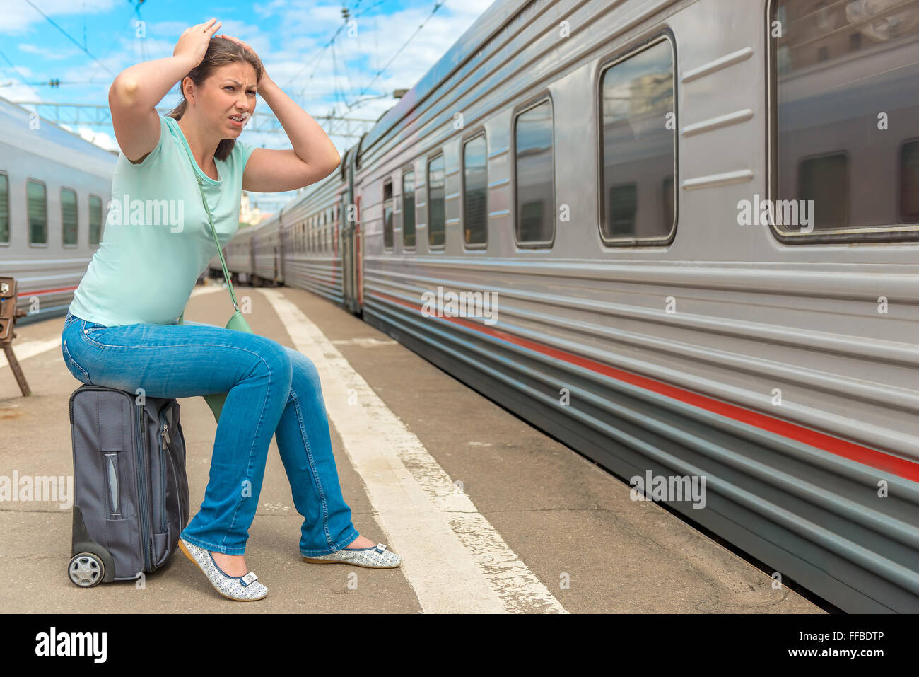 frustrated woman looking at the passing train on which she was late ...
