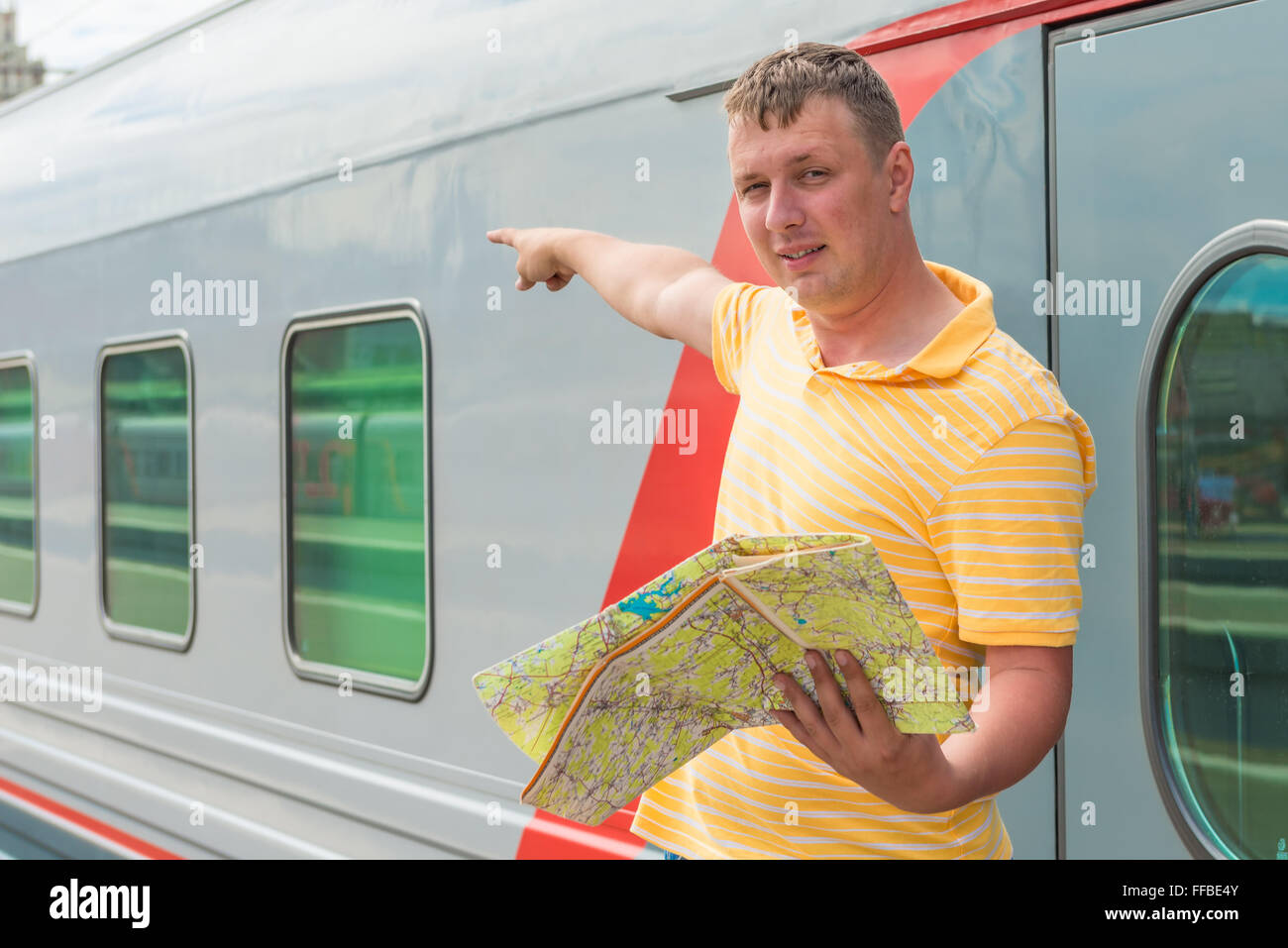 the man with a map shows the direction of the train station Stock Photo ...