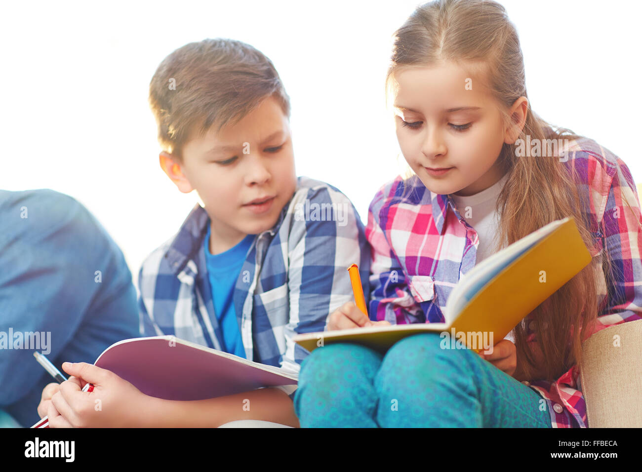 Little pupils making notes in their copybooks Stock Photo - Alamy