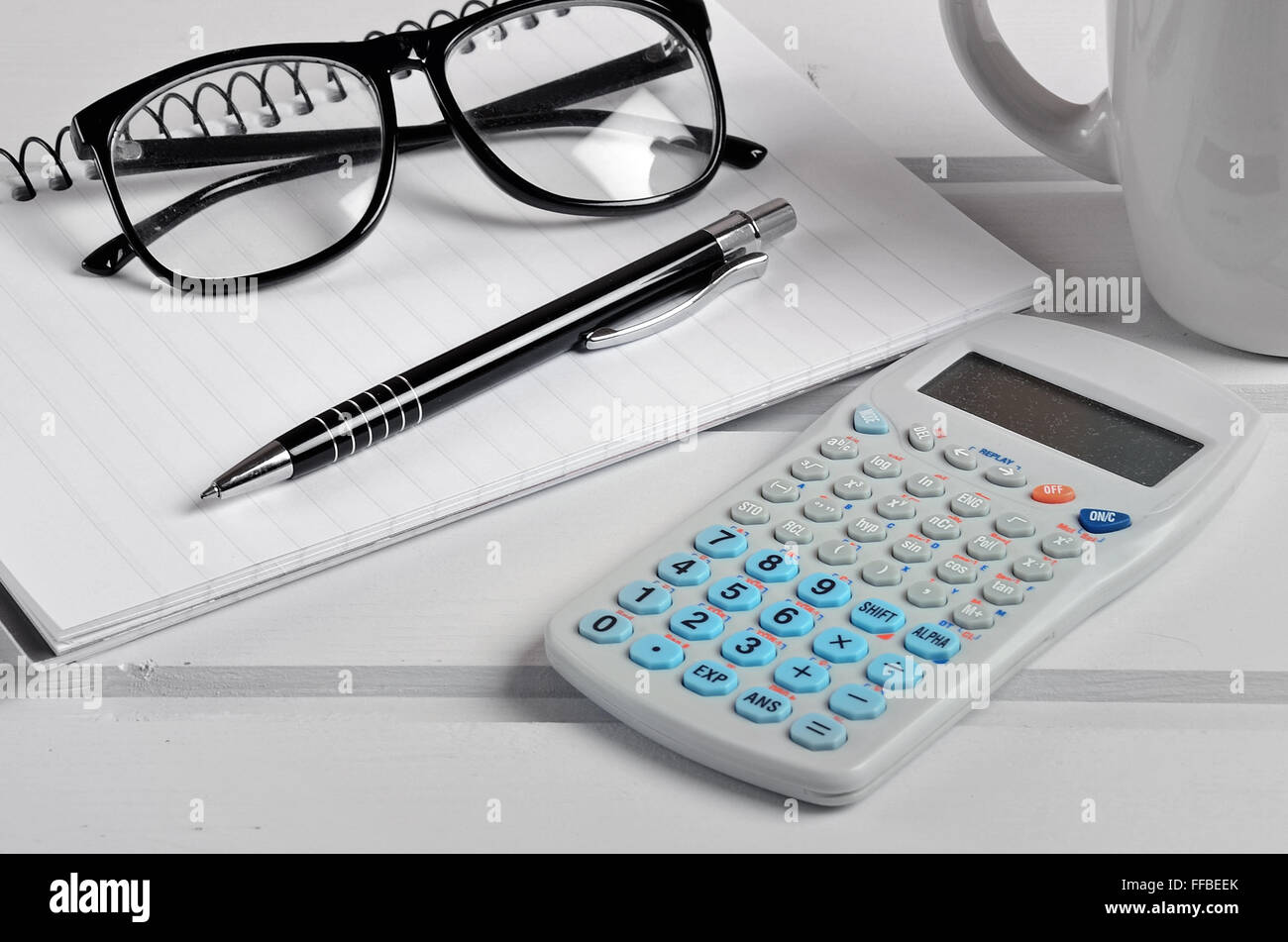 Notebook with eyeglasses,calculator and pen Stock Photo - Alamy
