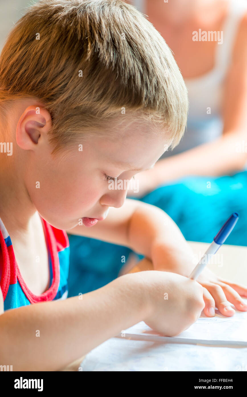 Portrait of a boy drawing a pen on paper closeup Stock Photo - Alamy