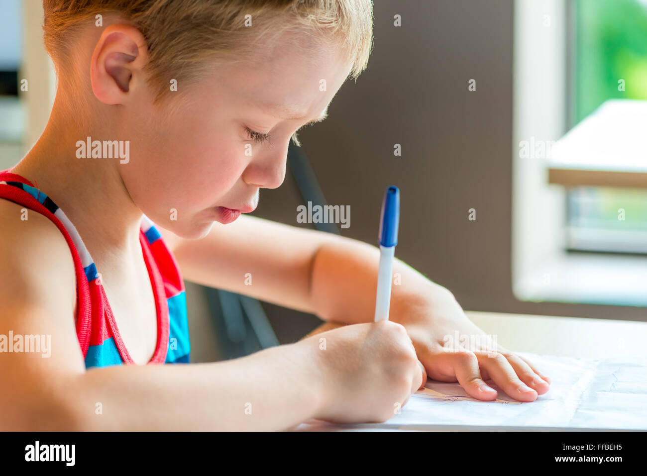 concentrated boy draws a pen on paper Stock Photo - Alamy