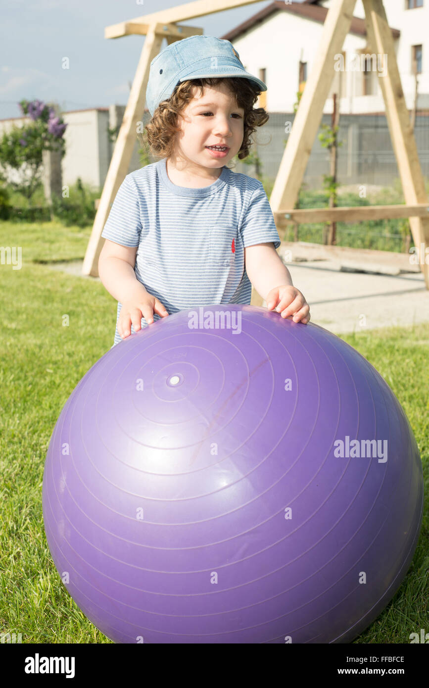 Toddler boy playing with big ball outside in garden Stock Photo - Alamy