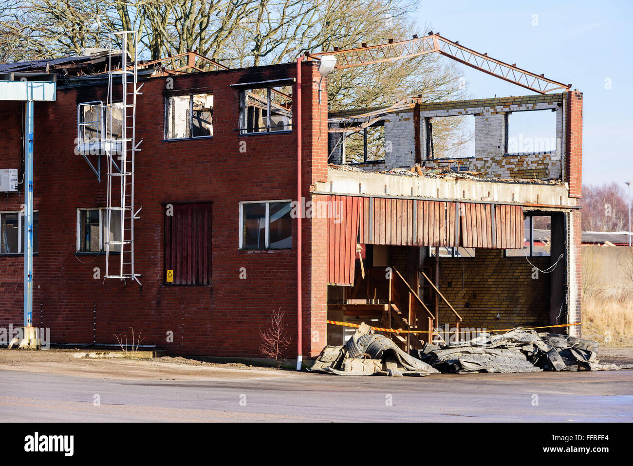 A small industrial building has burnt down. The roof is gone and some ...