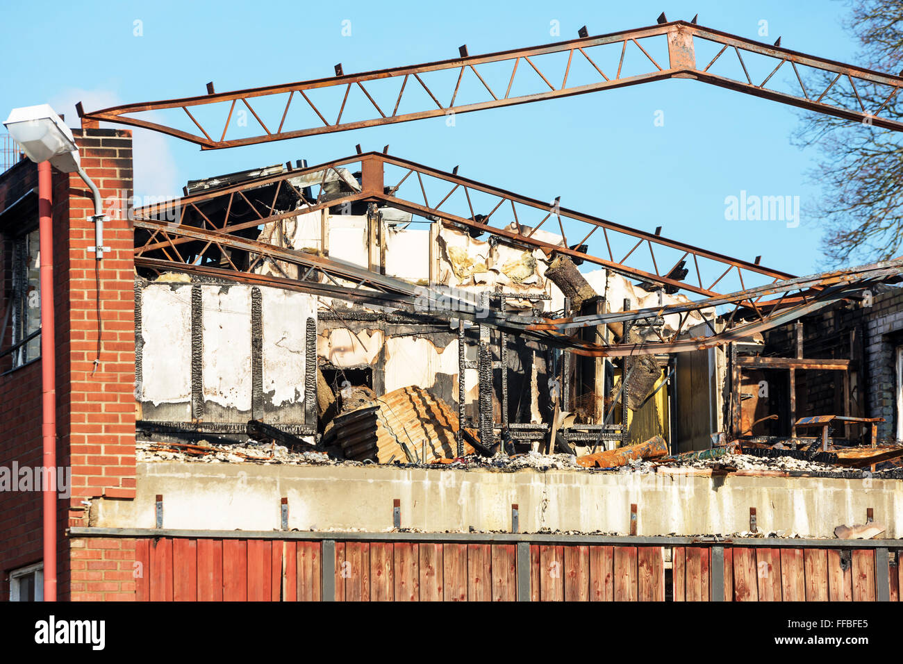 A small industrial building has burnt down. The roof is gone and some ...