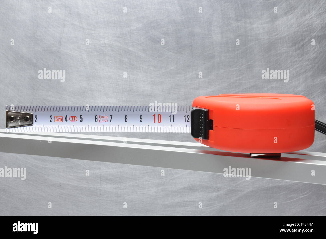 Single red tape measure on grey metal background Stock Photo - Alamy