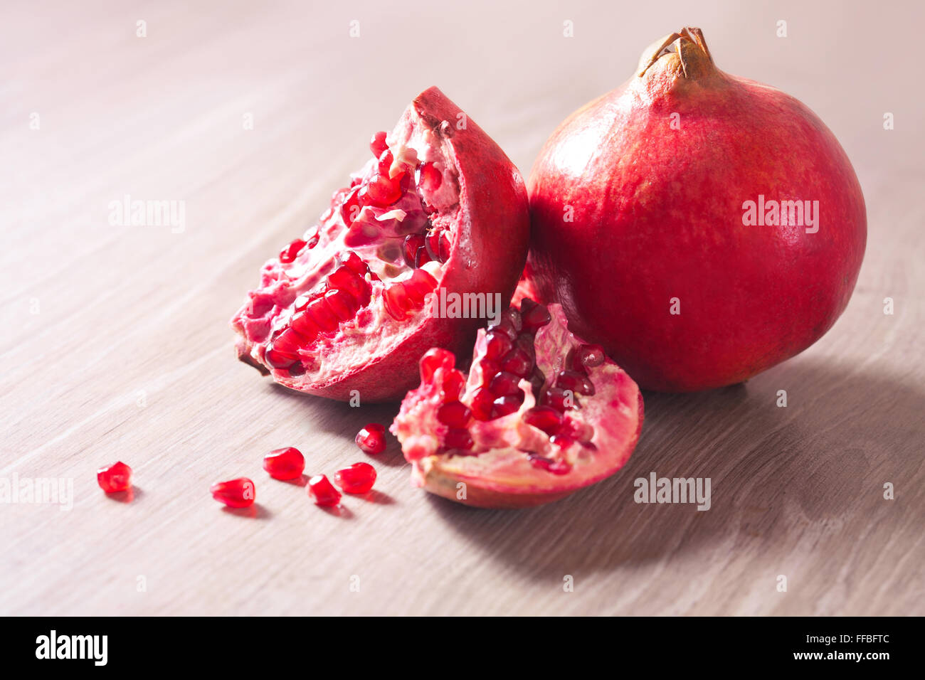 Close up sliced and whole pomegranate on a table Stock Photo - Alamy