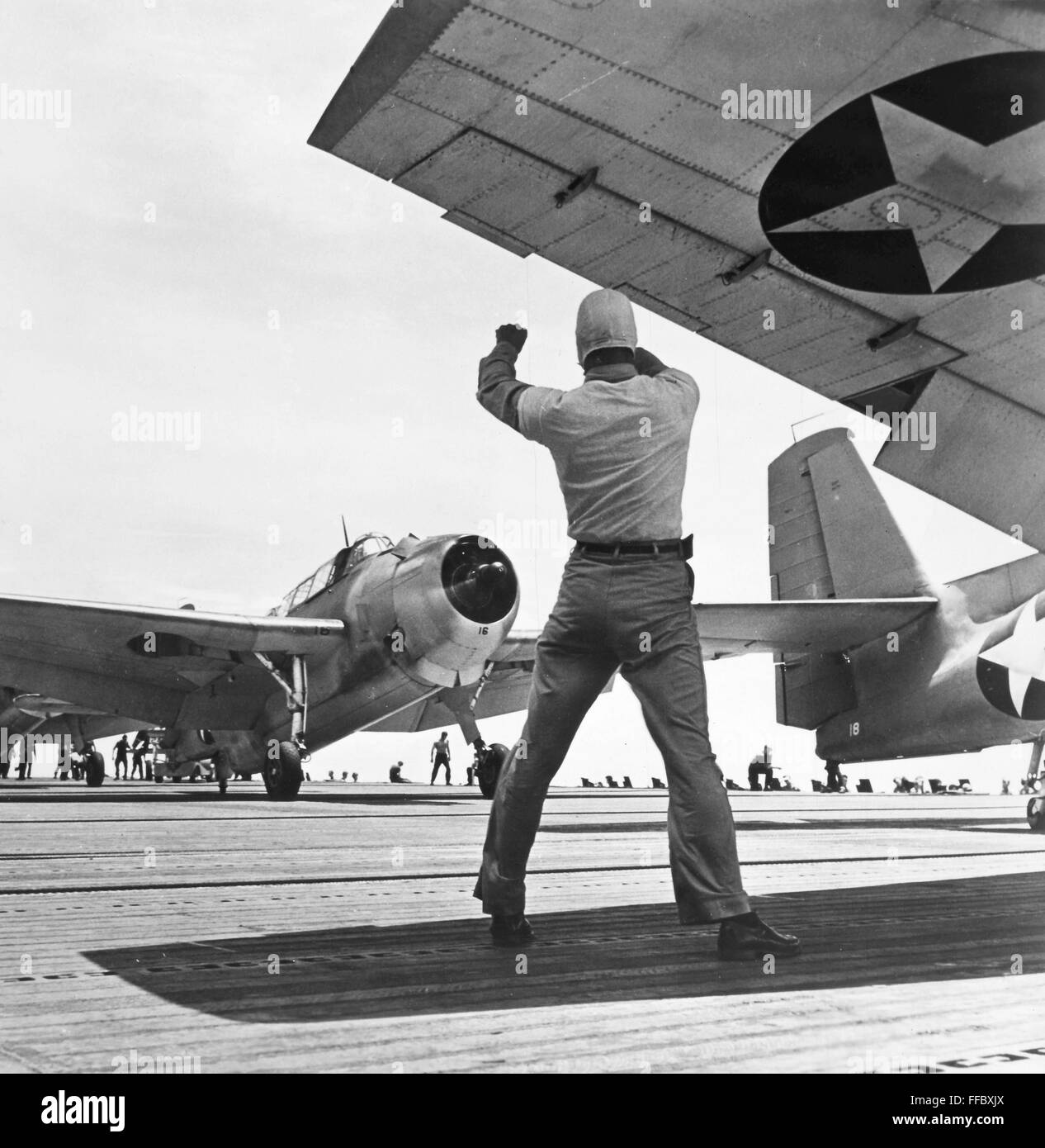 THE FIGHTING LADY, 1944. /nA signal officer directs a fighter plane on ...