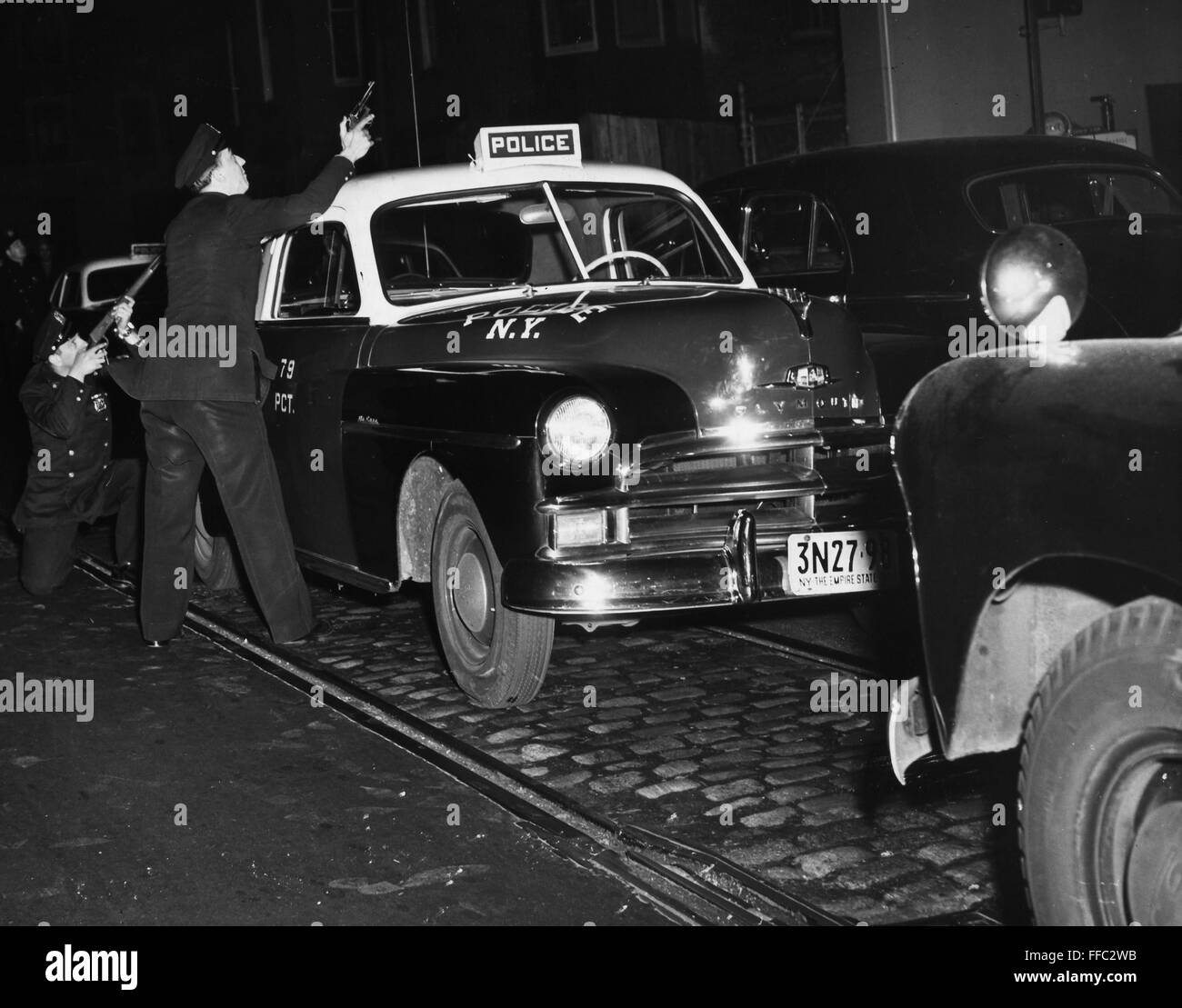 NYC: POLICE OFFICERS. /nPolicemen take cover from behind their cars ...
