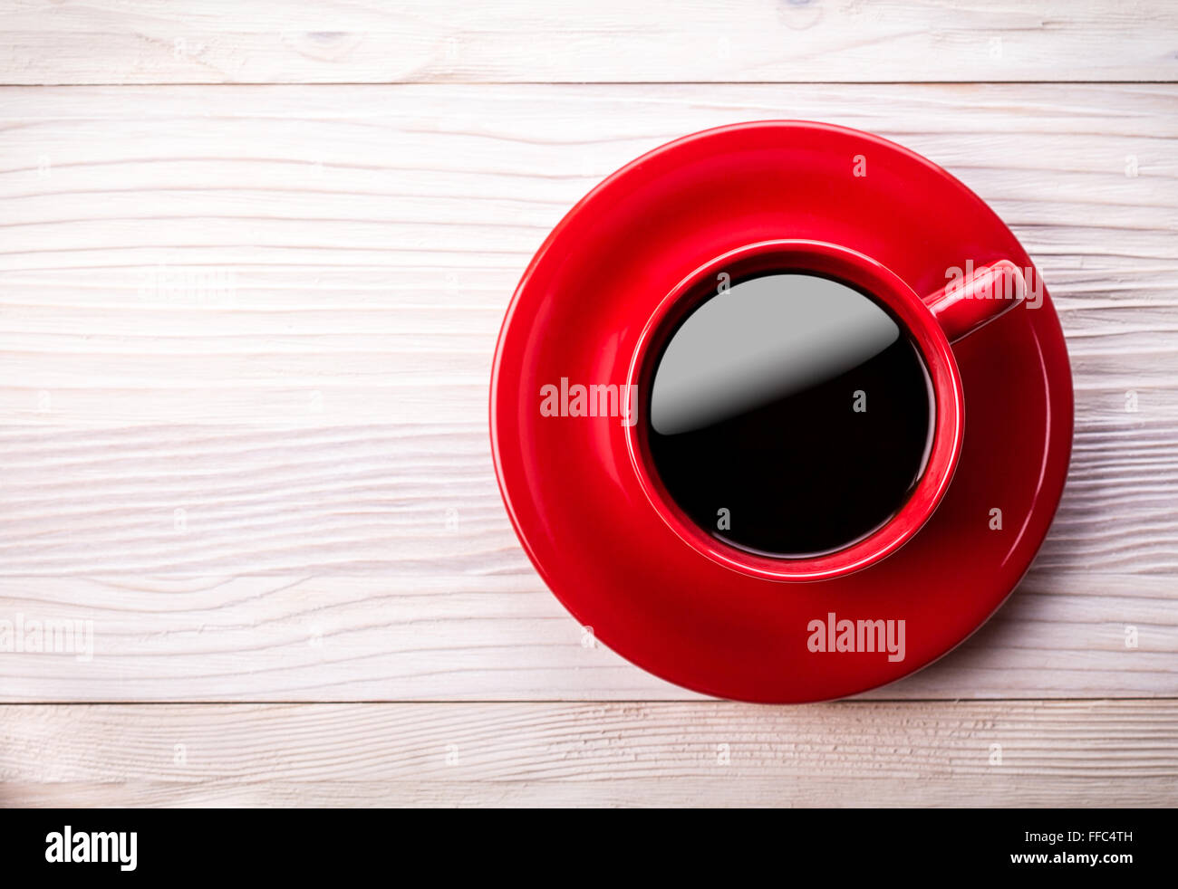 Red coffee cup full of cofee on light wooden table Stock Photo - Alamy