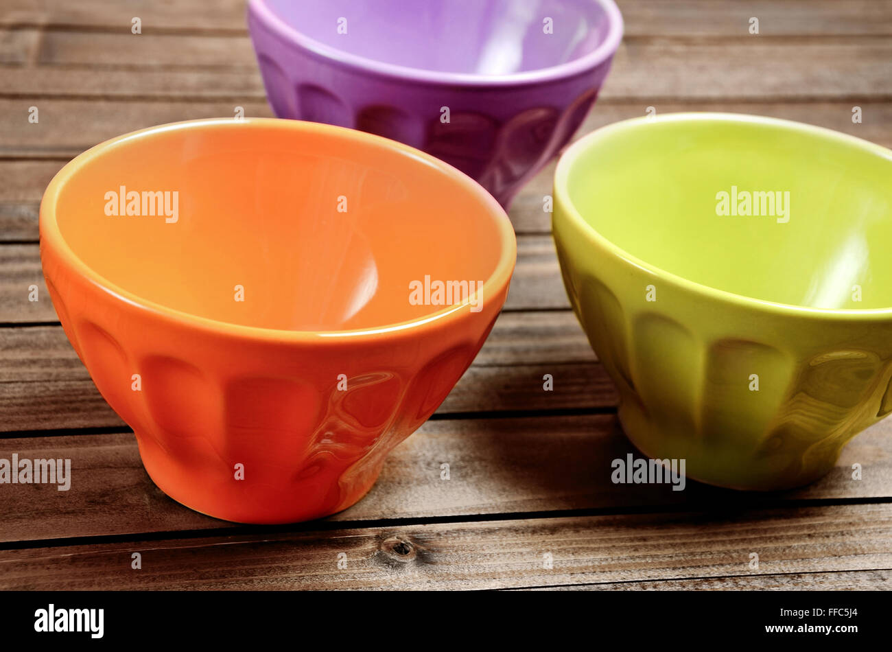 Colorful bowl on wooden table Stock Photo - Alamy