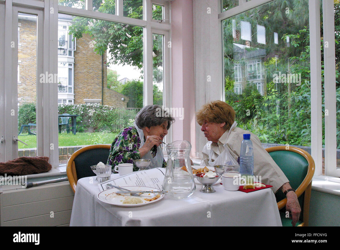 Elderly residents having discussions over lunch in Schonfeld square ...