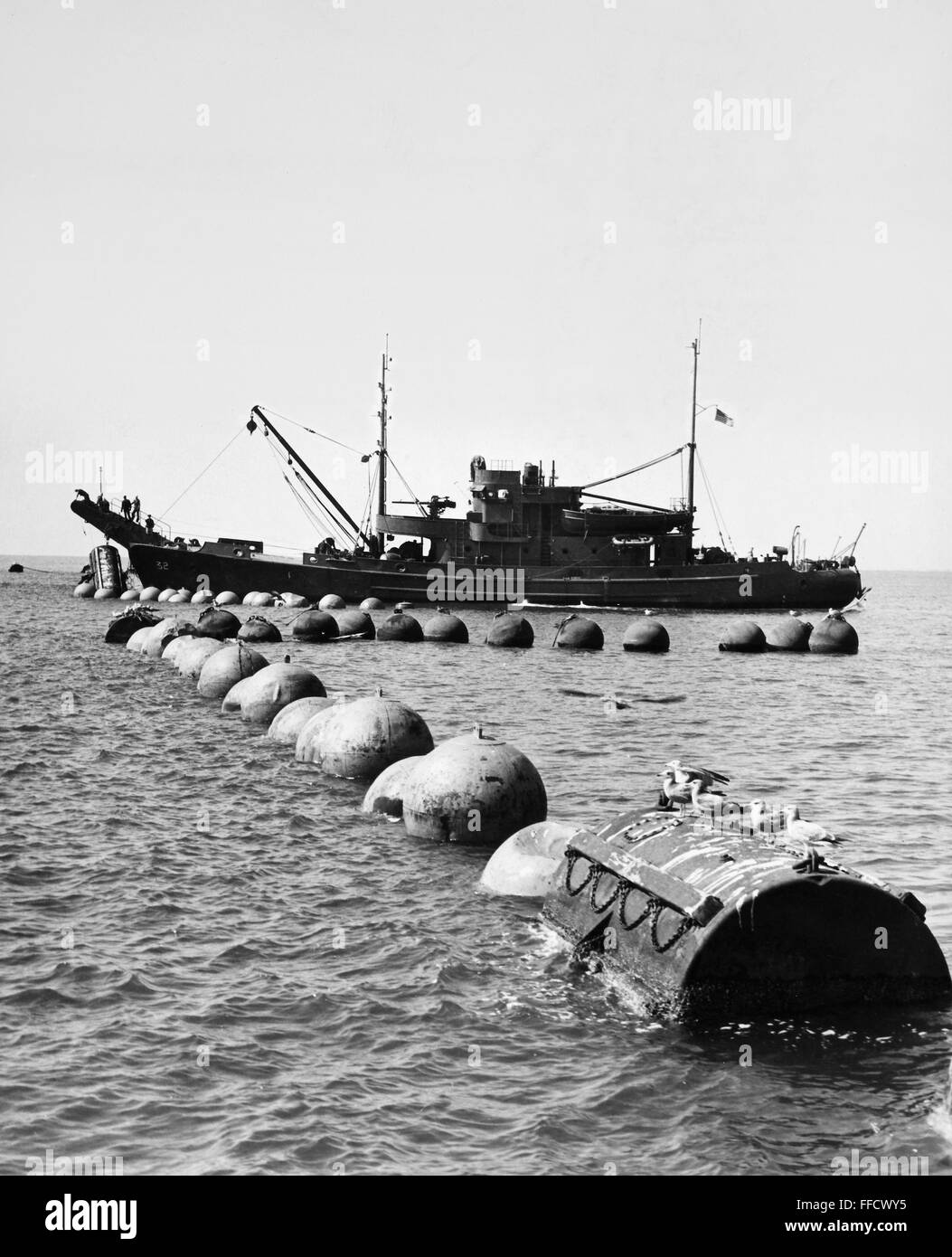 WORLD WAR II: TORPEDO NET. /nA U.S. Navy ship laying an anti-torpedo ...