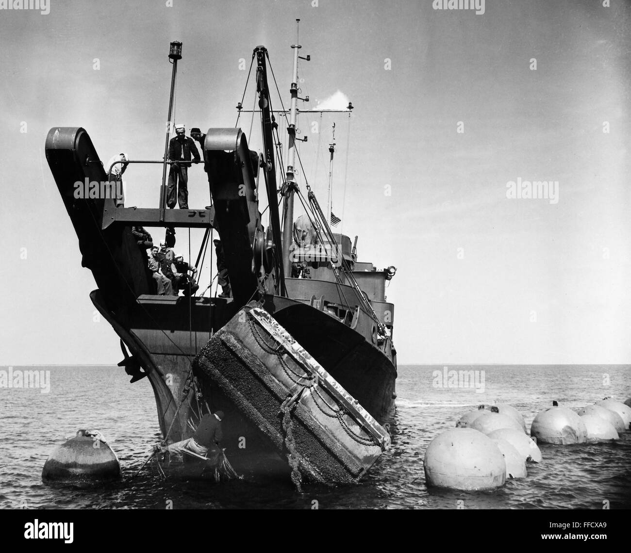 WORLD WAR II: TORPEDO NET. /nA U.S. Navy ship laying an anti-torpedo ...