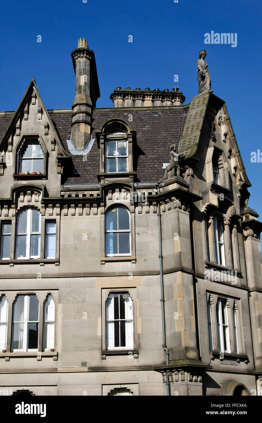 Ornate chimney stacks and carvings on the façade and roof of a building ...