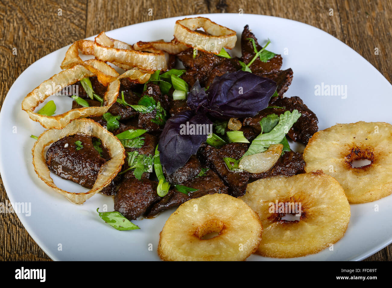 Grilled liver with onion rings and herbs Stock Photo - Alamy