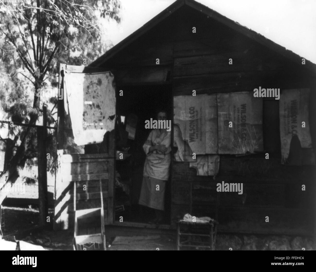 MIGRANT WORKER, 1935. /nMigrant women standing in doorway of the shack ...