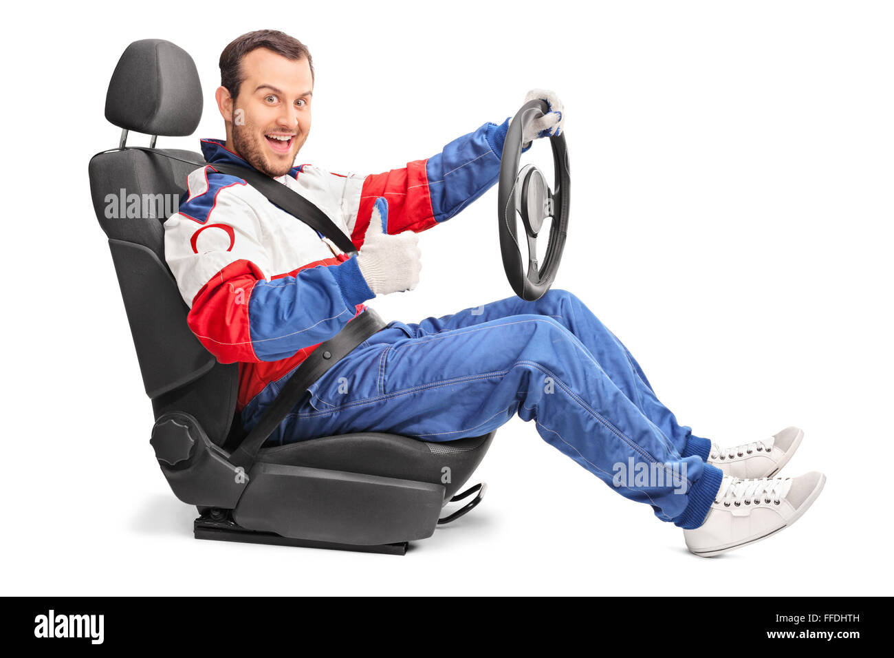 Joyful car racer sitting in a car seat and giving a thumb up isolated ...