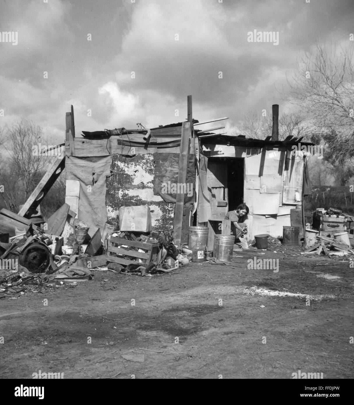 MIGRANT WORKER SHACK, 1935. /nA woman sitting in the doorway of her ...
