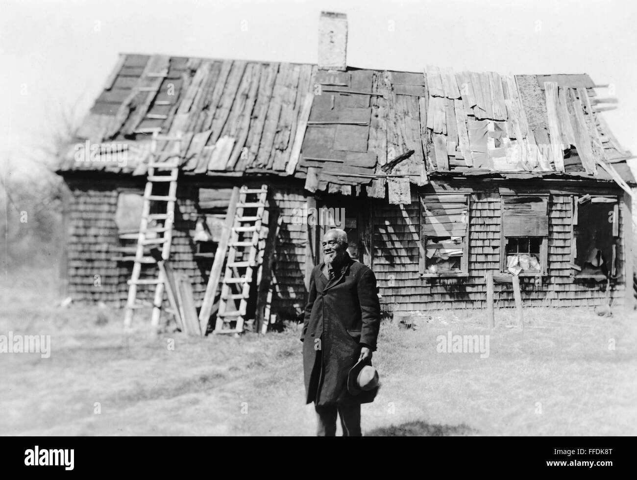 HENRY ROBINSON, c1937. /nAn former slave in front of his dilapidated ...