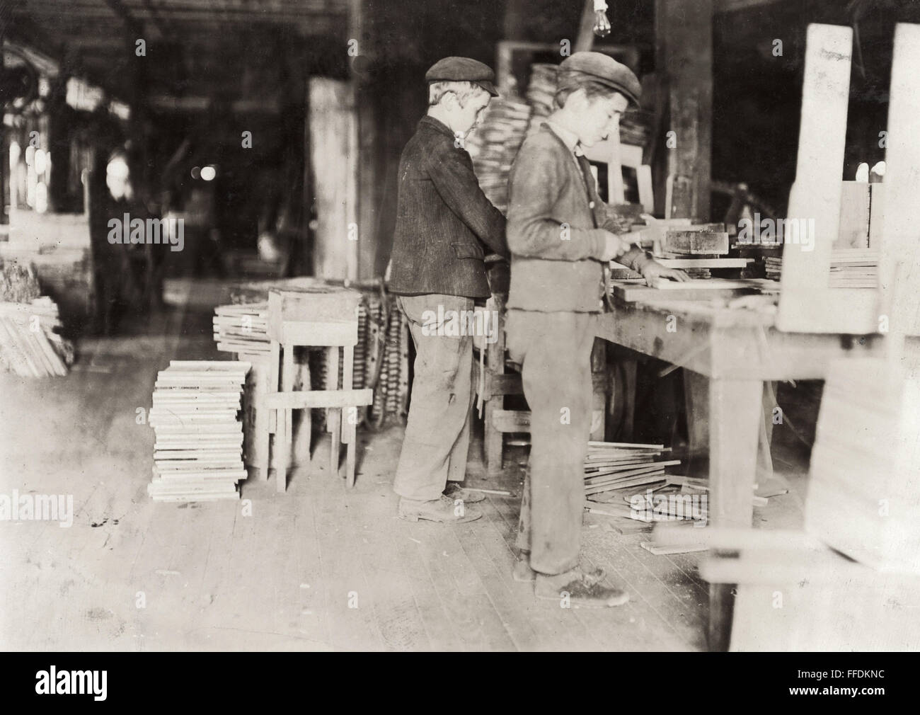 BASKET FACTORY, 1908. /nBoys making grate bottoms at a basket factory ...