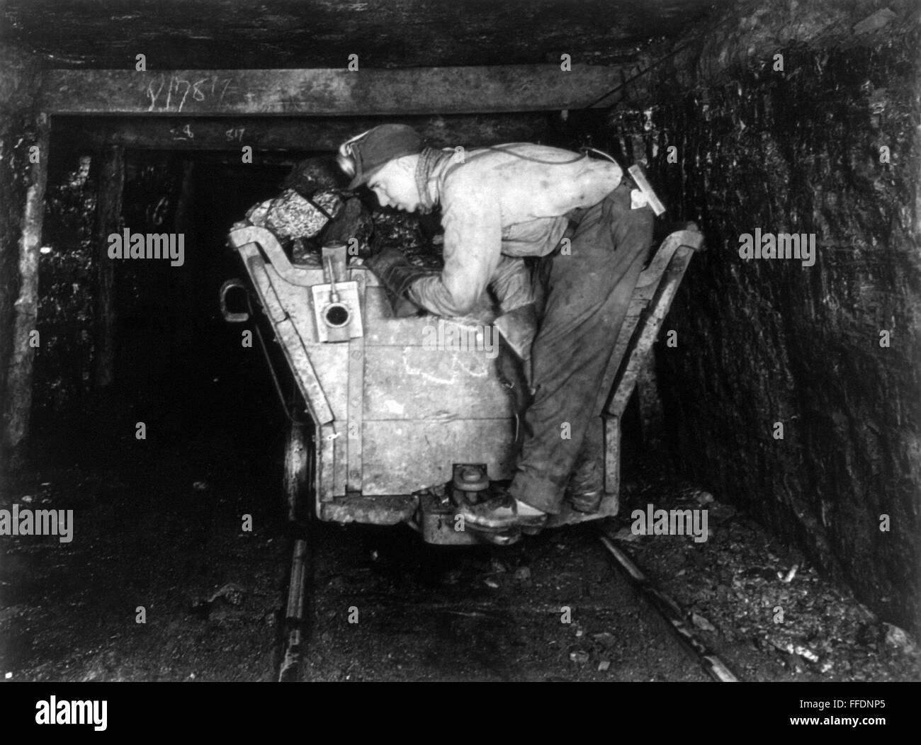 COAL MINER, c1915. /nA coal miner standing on the back of coal mining ...