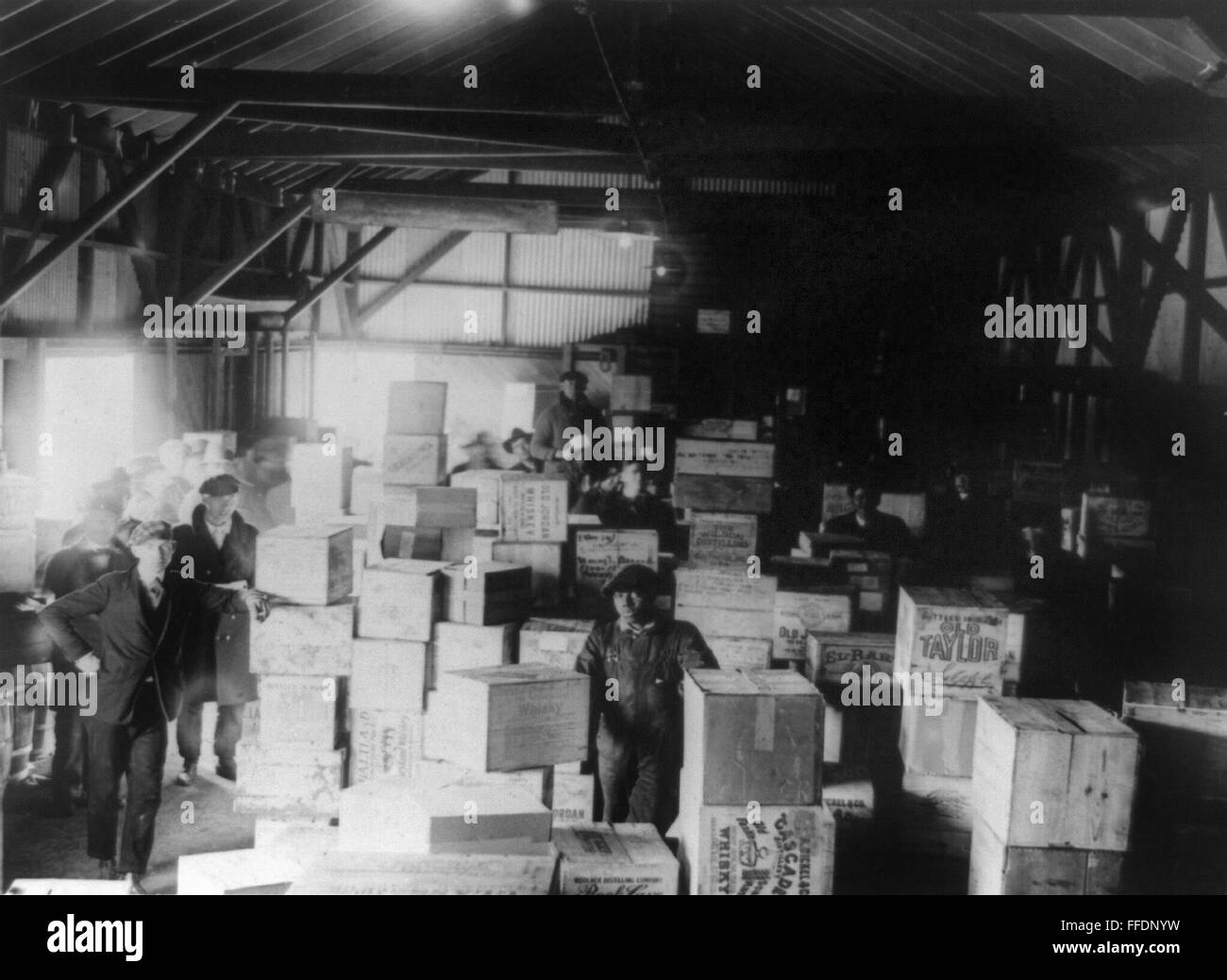 BOOTLEG LIQUOR, 1920s. /nMen standing in a warehouse filled with cases ...