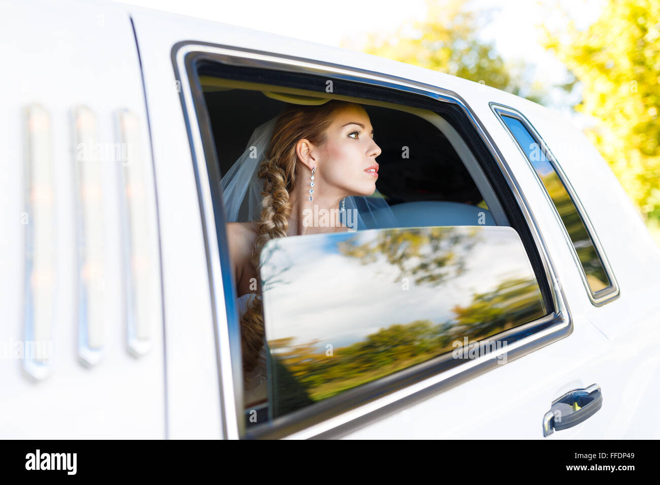 Bride looks out of the window a white limousine Stock Photo - Alamy