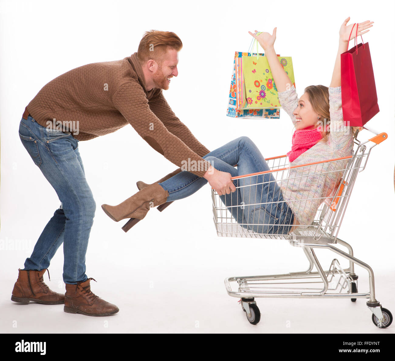 Happy couple with shopping cart Stock Photo - Alamy