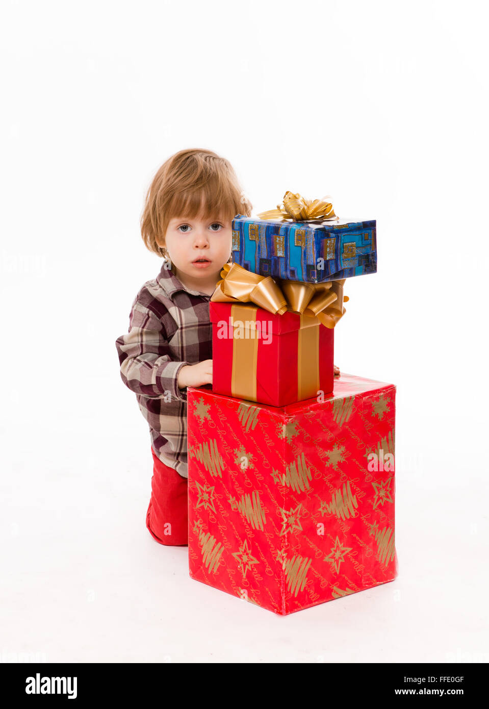 Little baby hiding behind presents Stock Photo - Alamy
