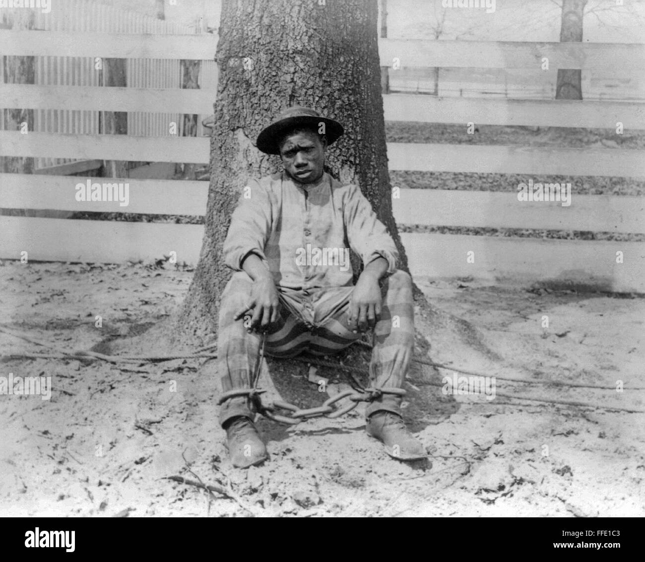 GEORGIA: CHAIN GANG./nAfrican American man sitting against a tree with ...
