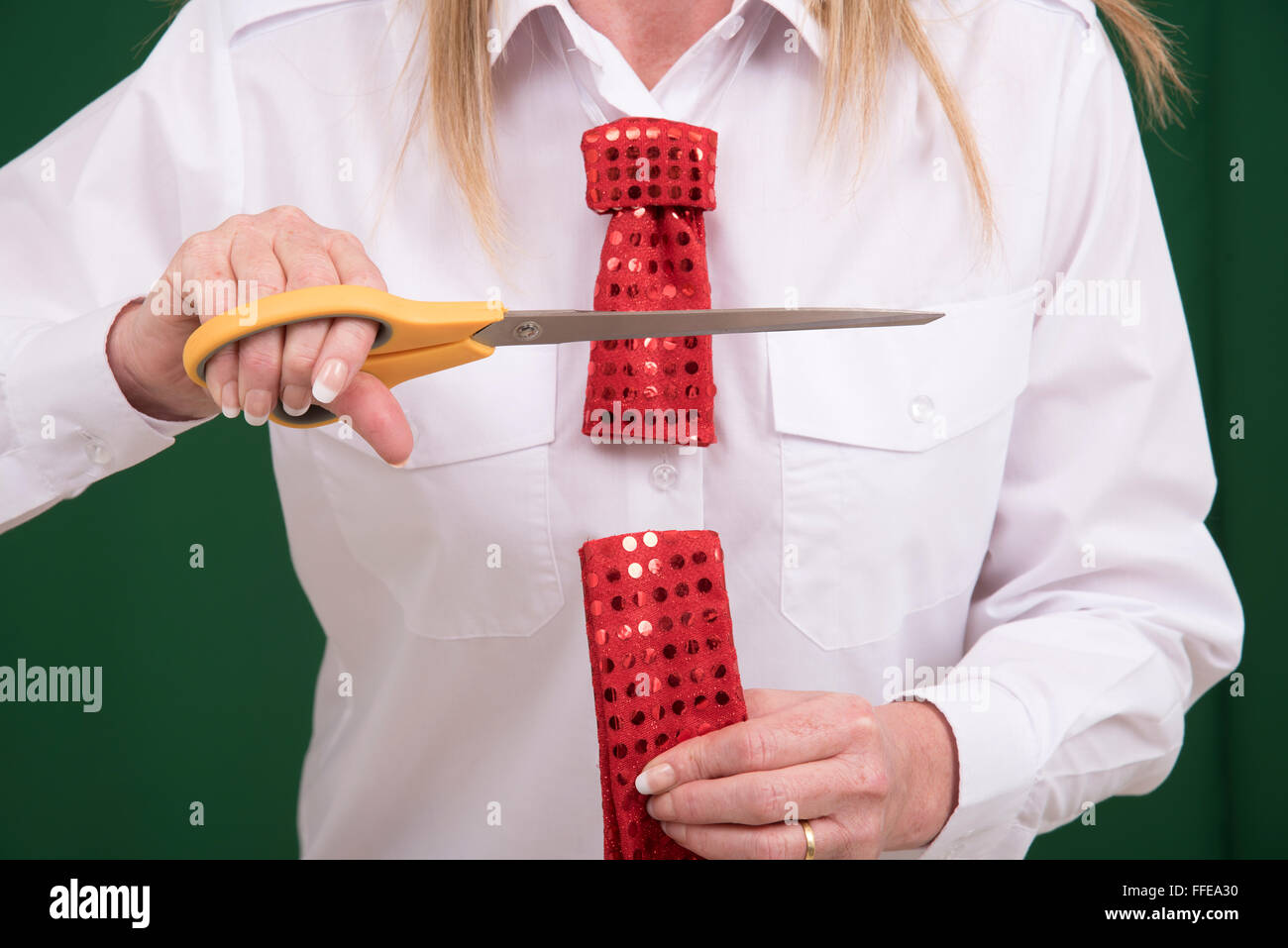 Woman having fun cutting a red necktie in half using a large pair of ...