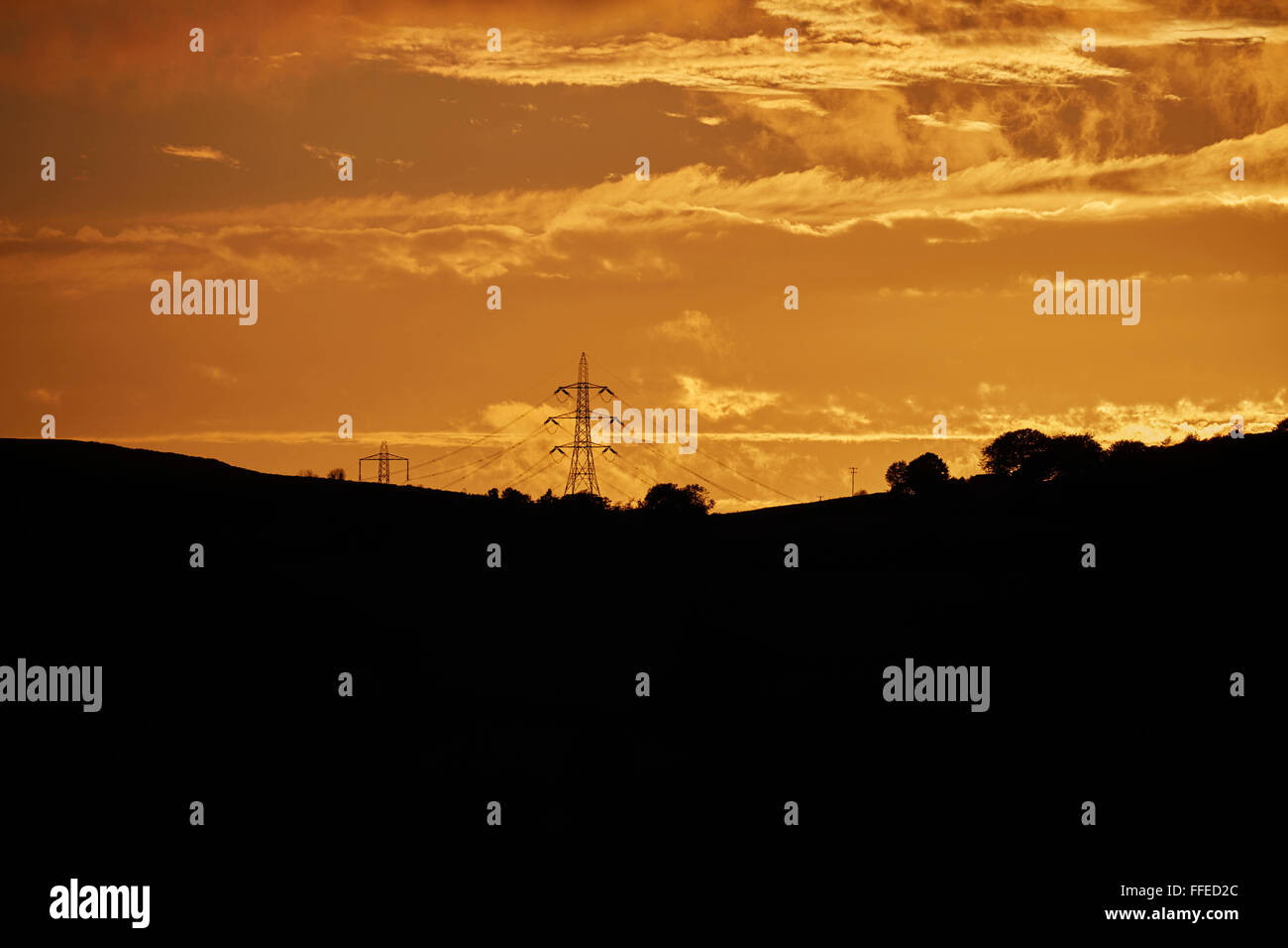 Dorset golden sunset with hills and electricity pylons backlit Stock ...