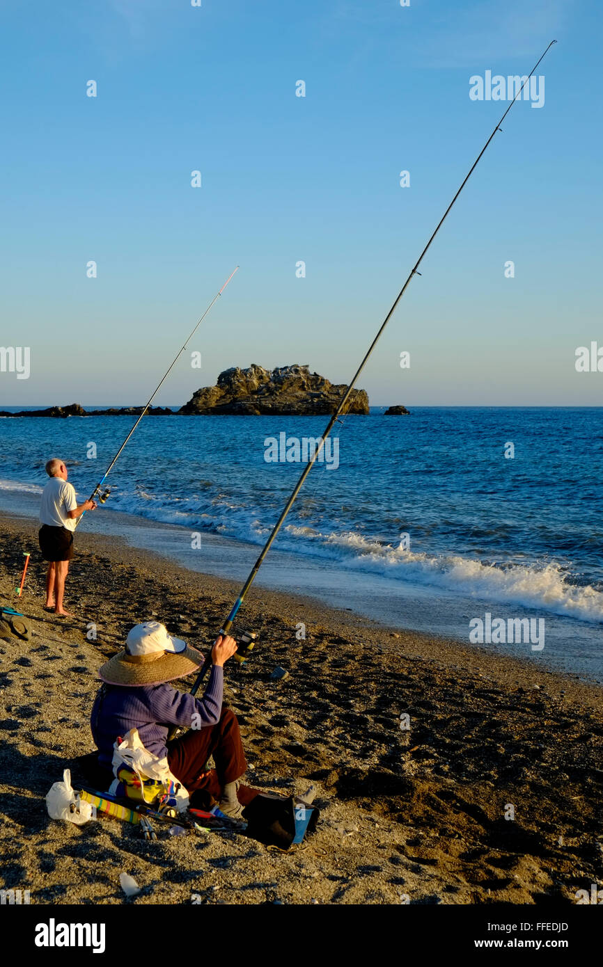 Two anglers fishing from the beach as the sun is going down. Almuñécar ...