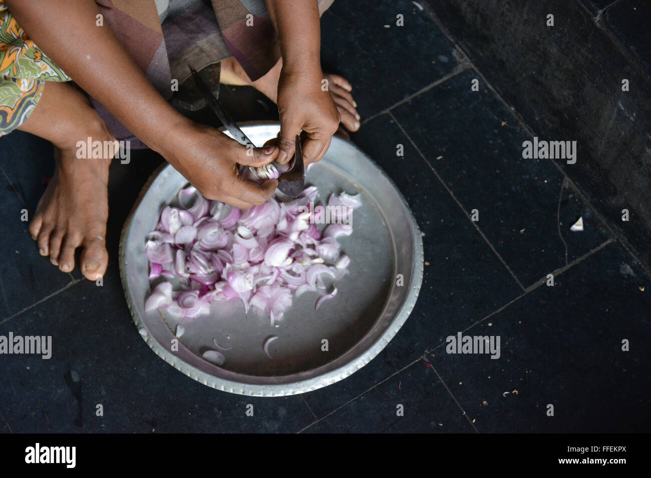 Mumbai, India - October 28, 2015 - Woman cutting chili and onions on a ...