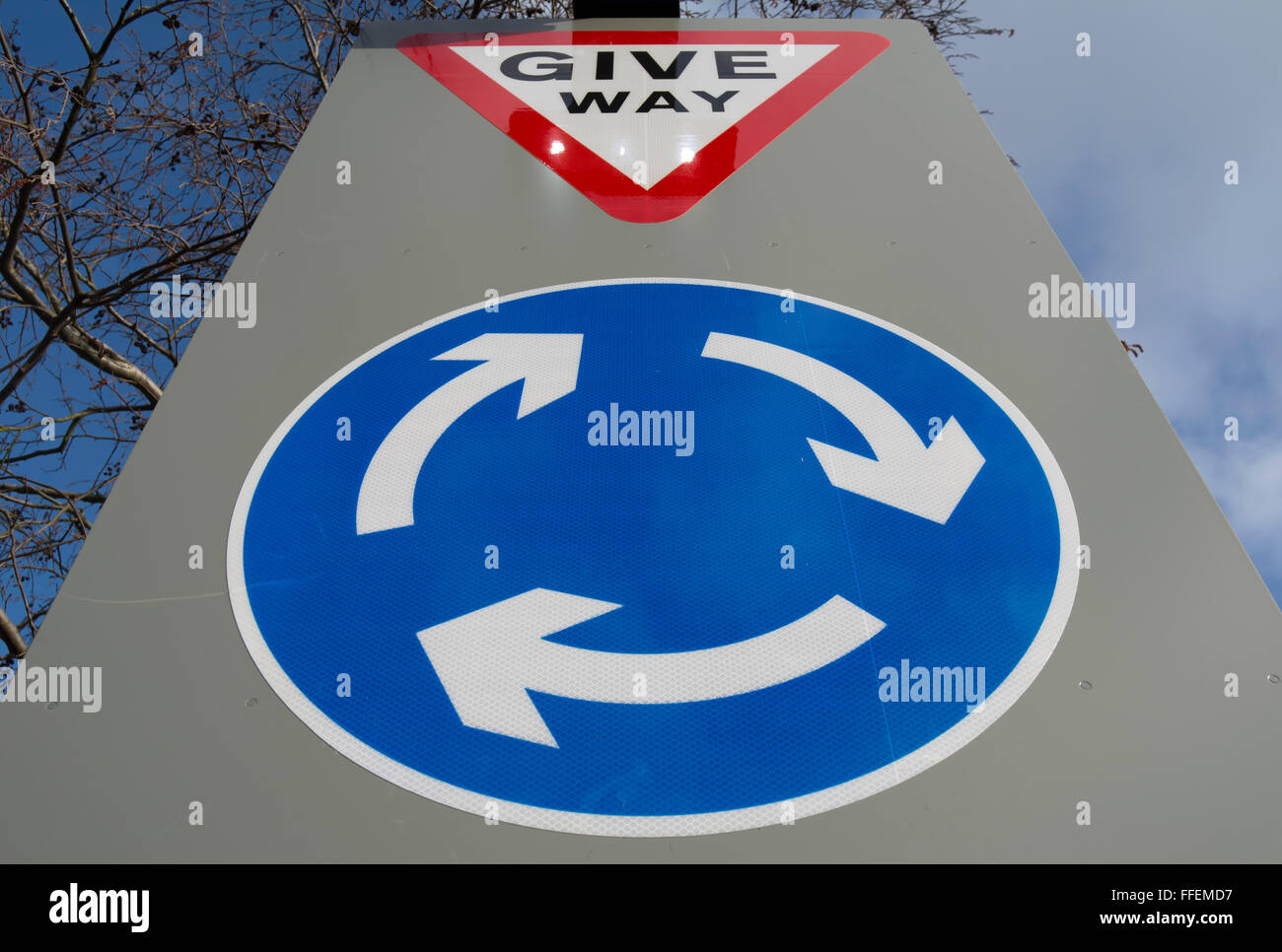 british road sign indicating a roundabout ahead and instructing road ...